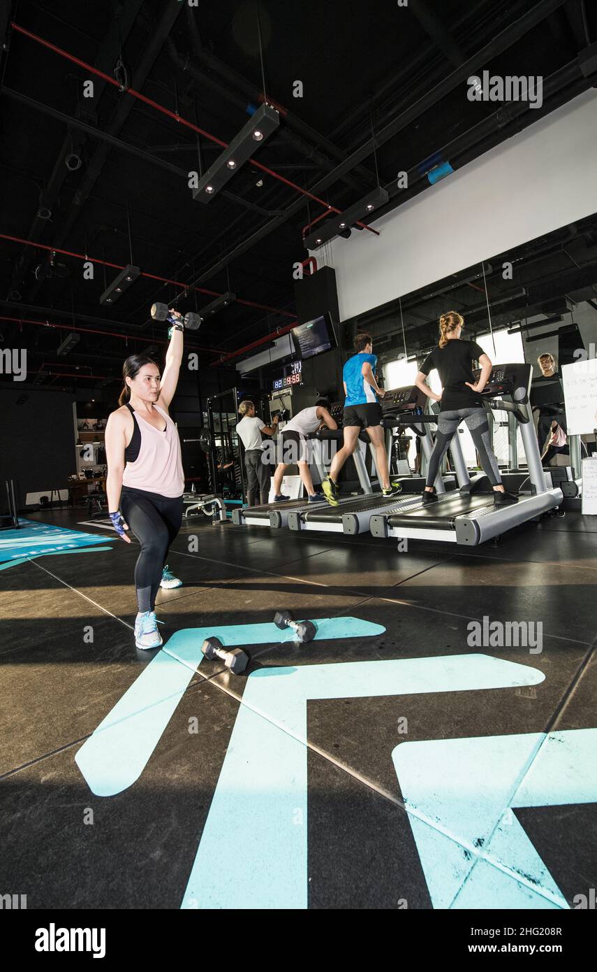 woman performing overhead press during workout at gym in Bangkok Stock ...