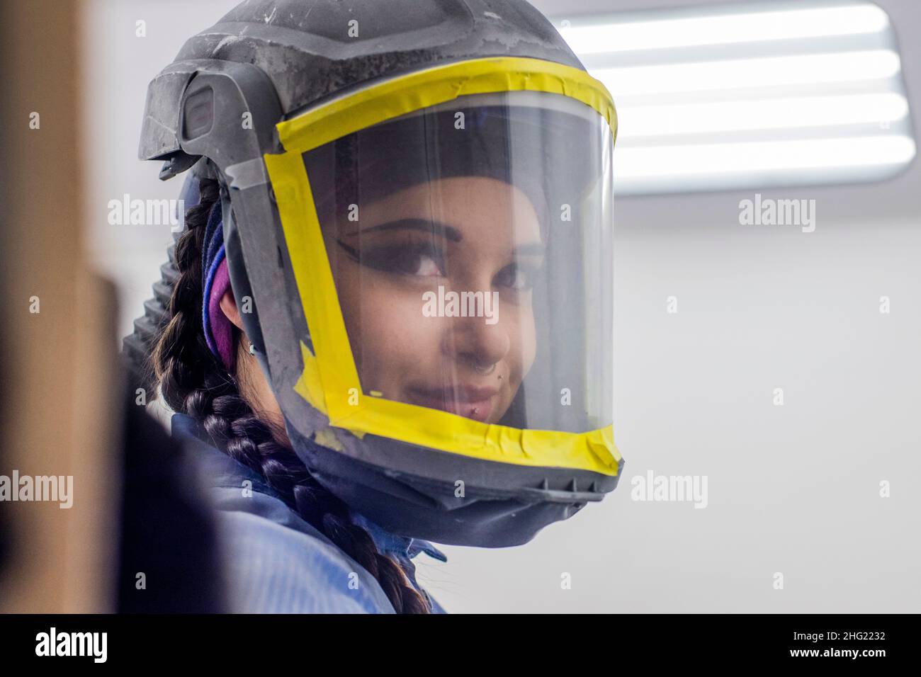 Female Auto worker with helmet mask on Stock Photo - Alamy