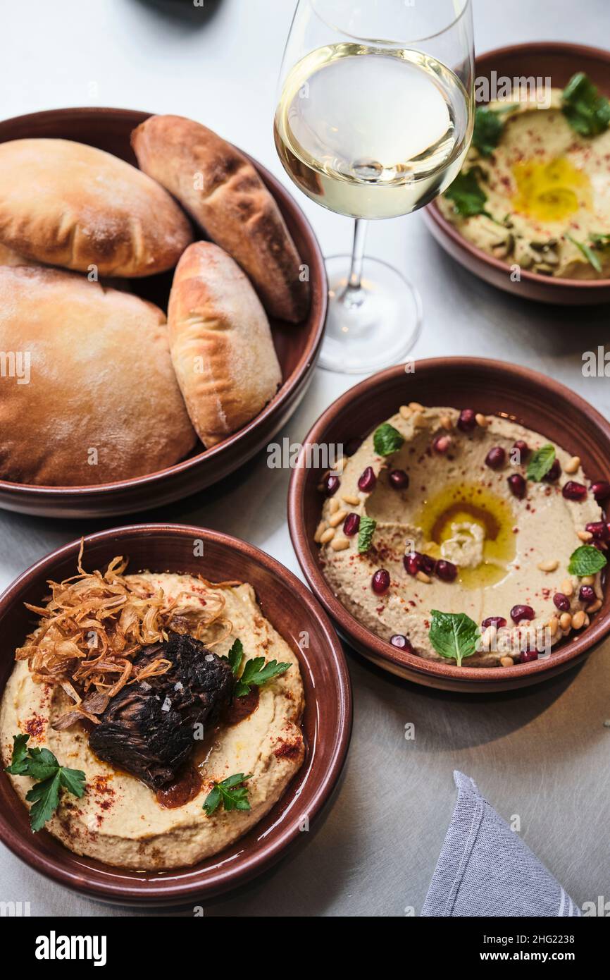Various types of gourmet hummus on a full table with bread Stock Photo ...
