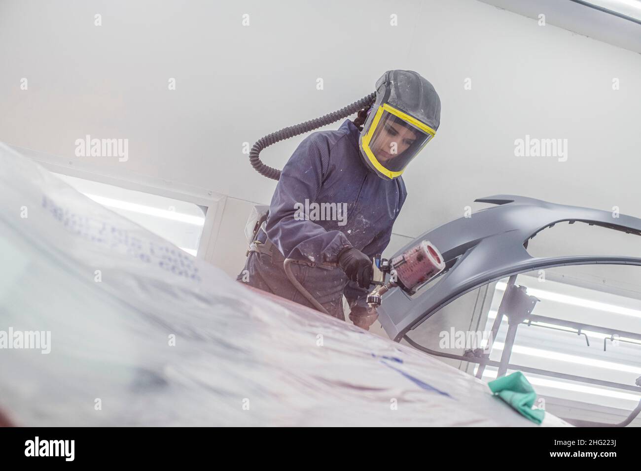 Female Auto worker painting car Stock Photo - Alamy
