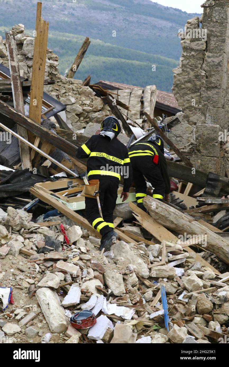 Rescue workers work in the rubble in the medieval town of Onna ...