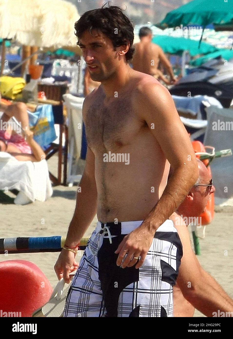 Football player Diego Milito spending a day on the beach with his son ...