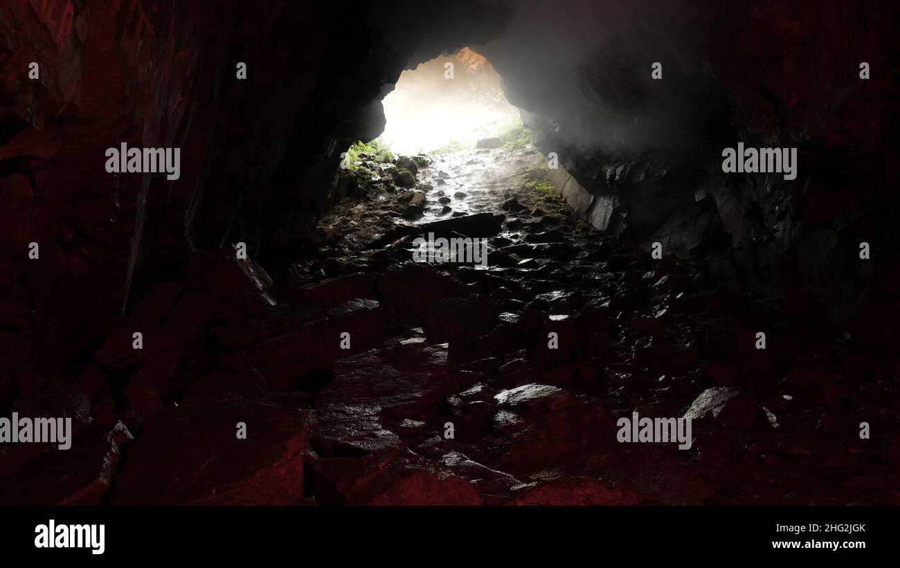 View from inside a cave with rocky path and daylight at the entrance ...