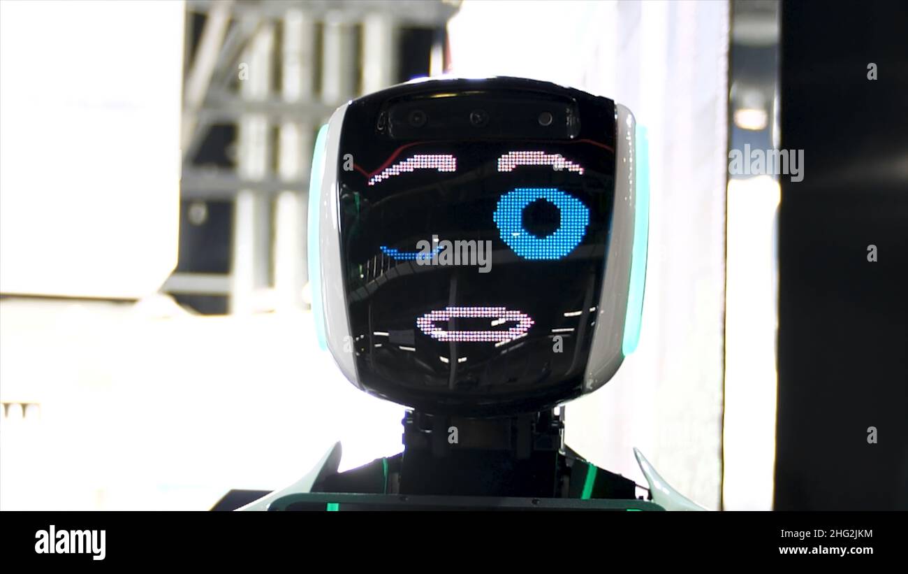 Funny robot with big blue eyes smiling, talking, and winking. Close up ...