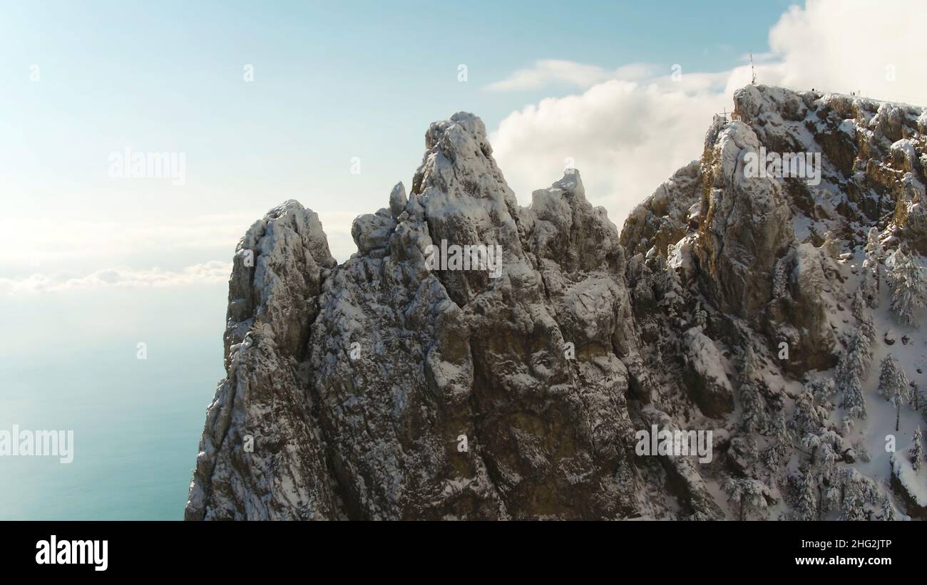 Close up for sharp rock formation on blue, cloudy sky background ...