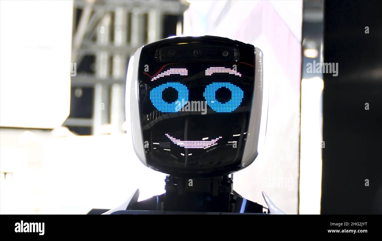 Funny robot with big blue eyes smiling and talking. Close up of robot ...