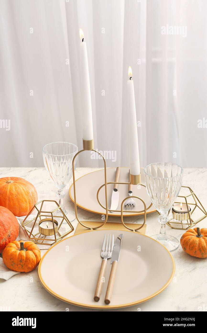 Beautiful table setting with candles and pumpkins Stock Photo - Alamy