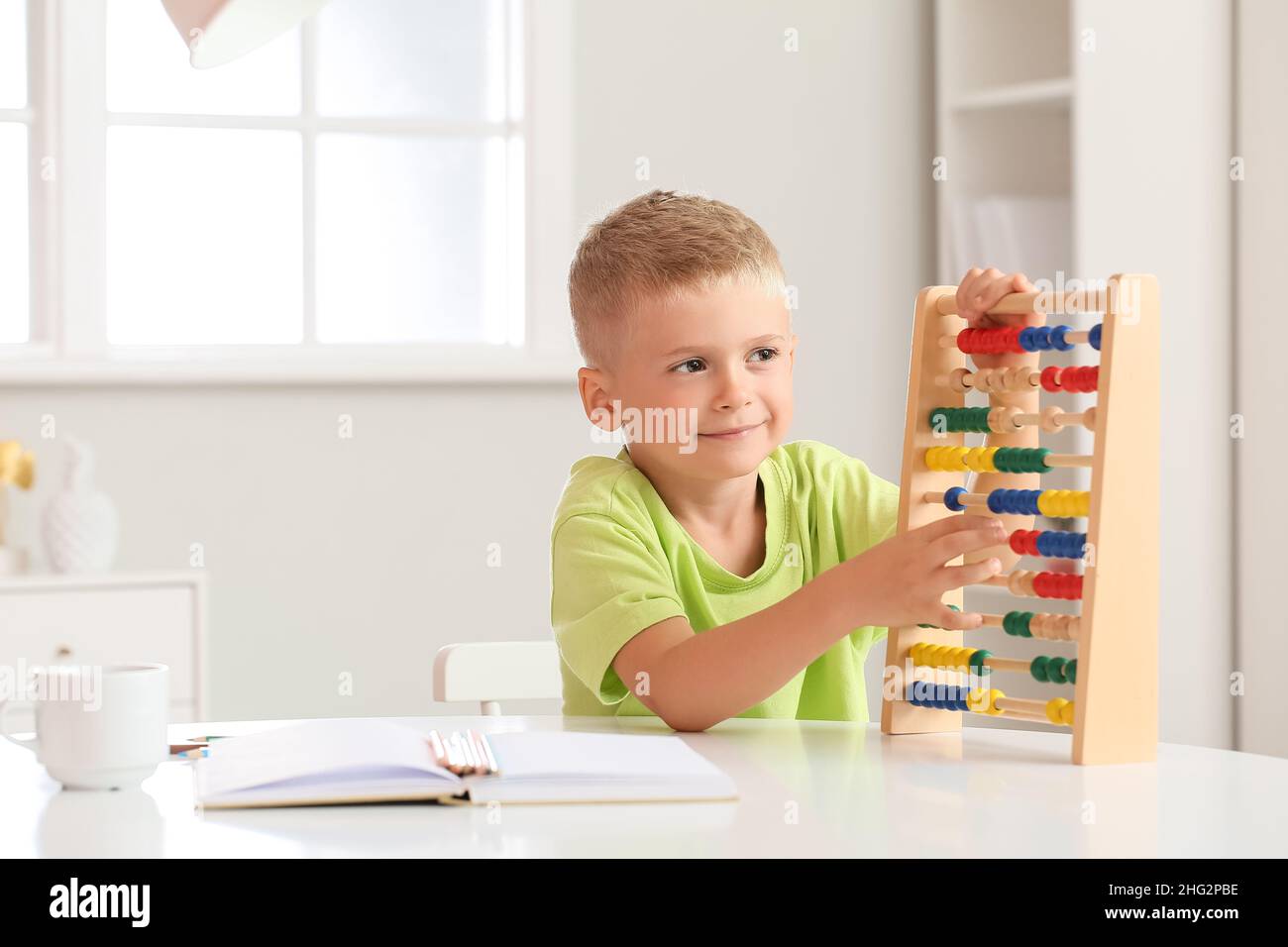 Adorable little boy learning math with abacus at home Stock Photo - Alamy