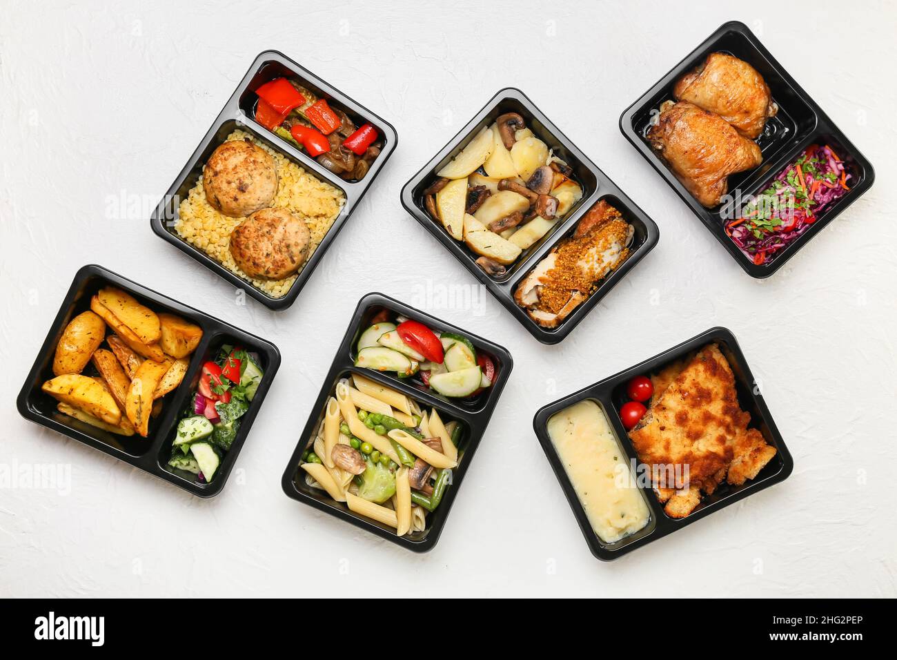 Lunch boxes with delicious food on light background Stock Photo - Alamy