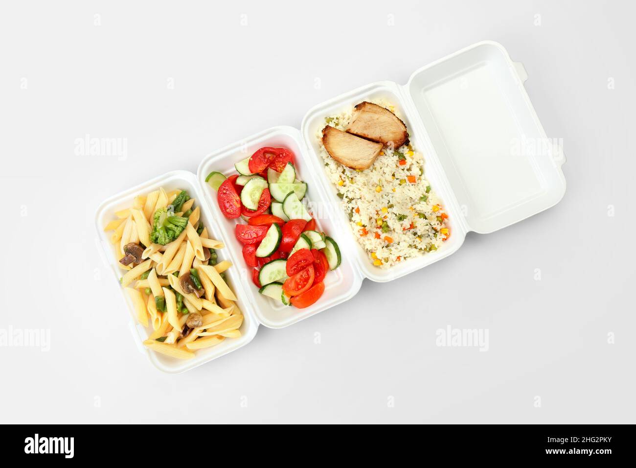Different delicious food in lunch boxes on light background Stock Photo ...