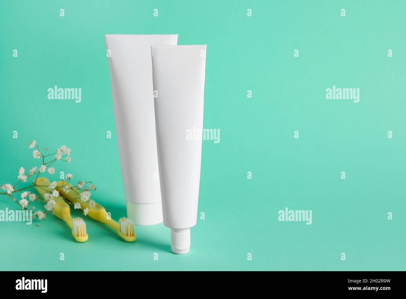 Tubes with toothpaste and toothbrushes on color background Stock Photo ...