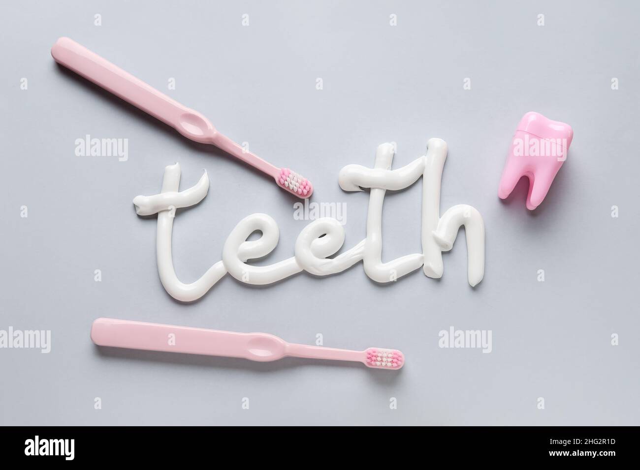 Toothbrushes, dental floss and word TEETH written with toothpaste on ...