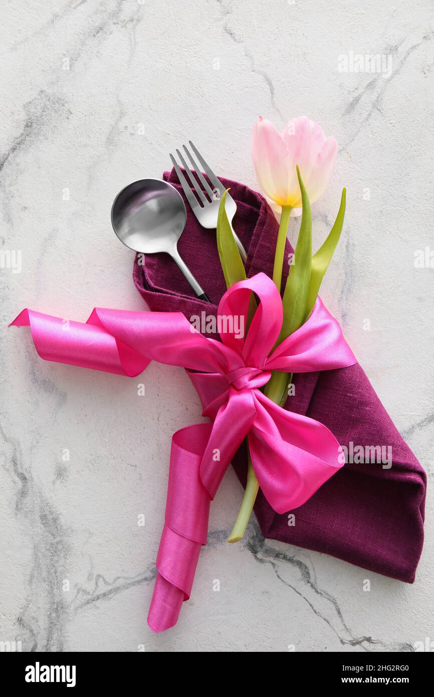 Beautiful cutlery and tulip flower on light background Stock Photo - Alamy