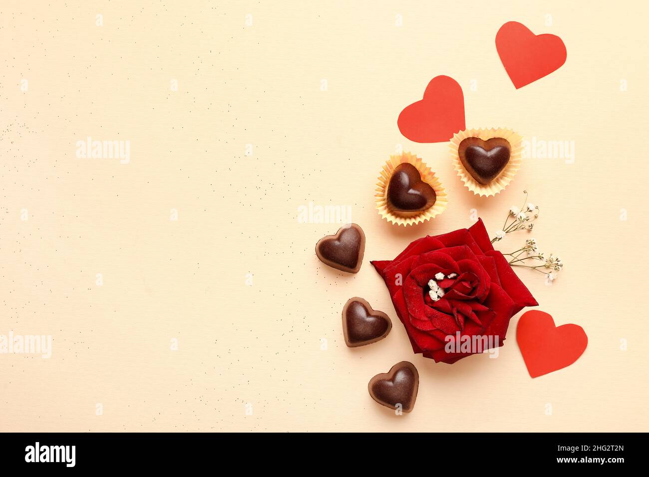 Tasty heart-shaped candies and flowers on beige background Stock Photo - Alamy