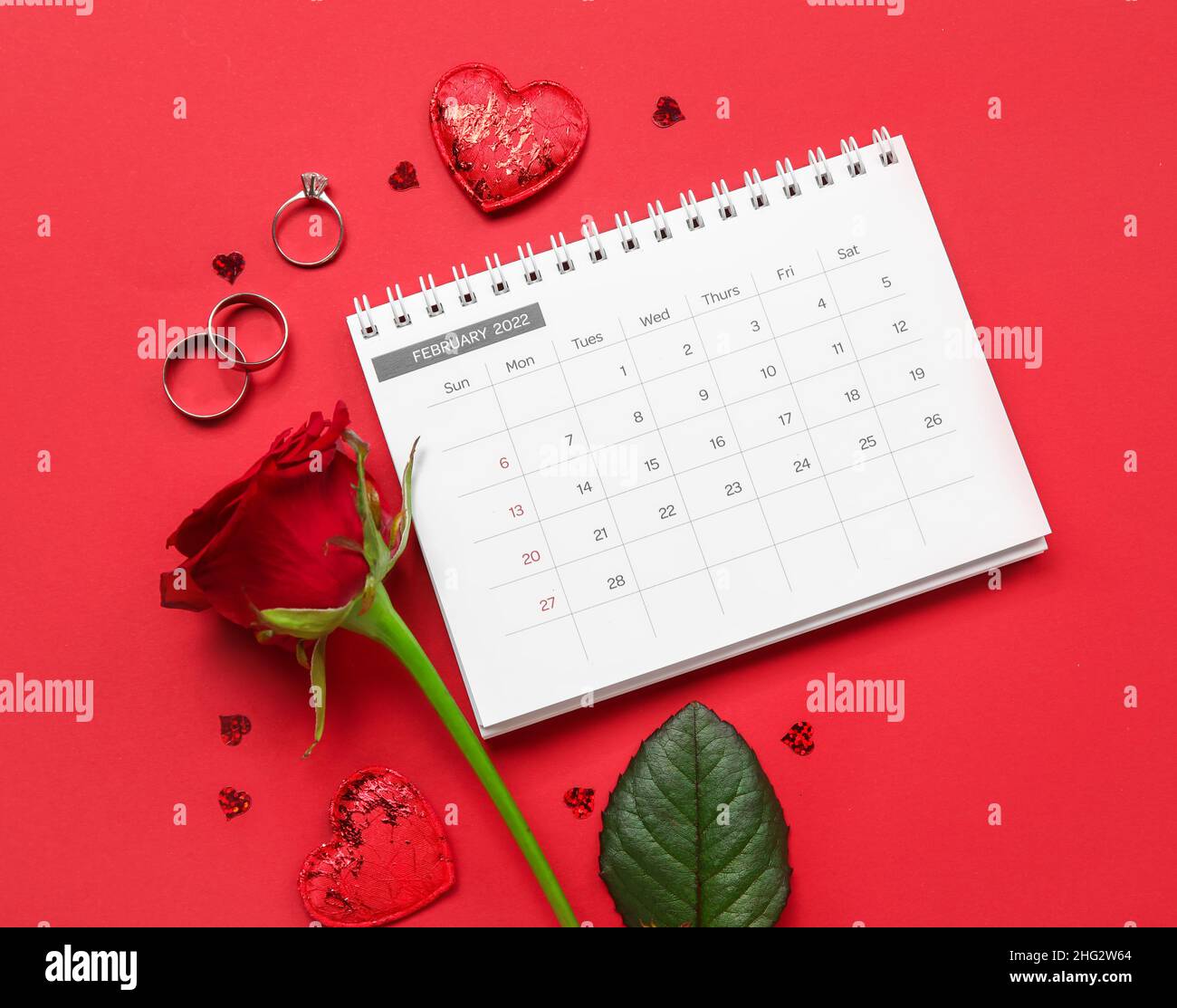 Calendar with rings, rose and hearts on red background. Valentine's Day ...