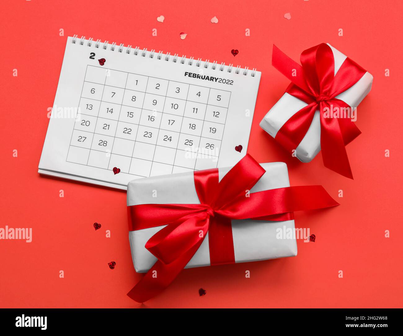 Calendar with hearts and gift boxes on red background. Valentine's Day ...