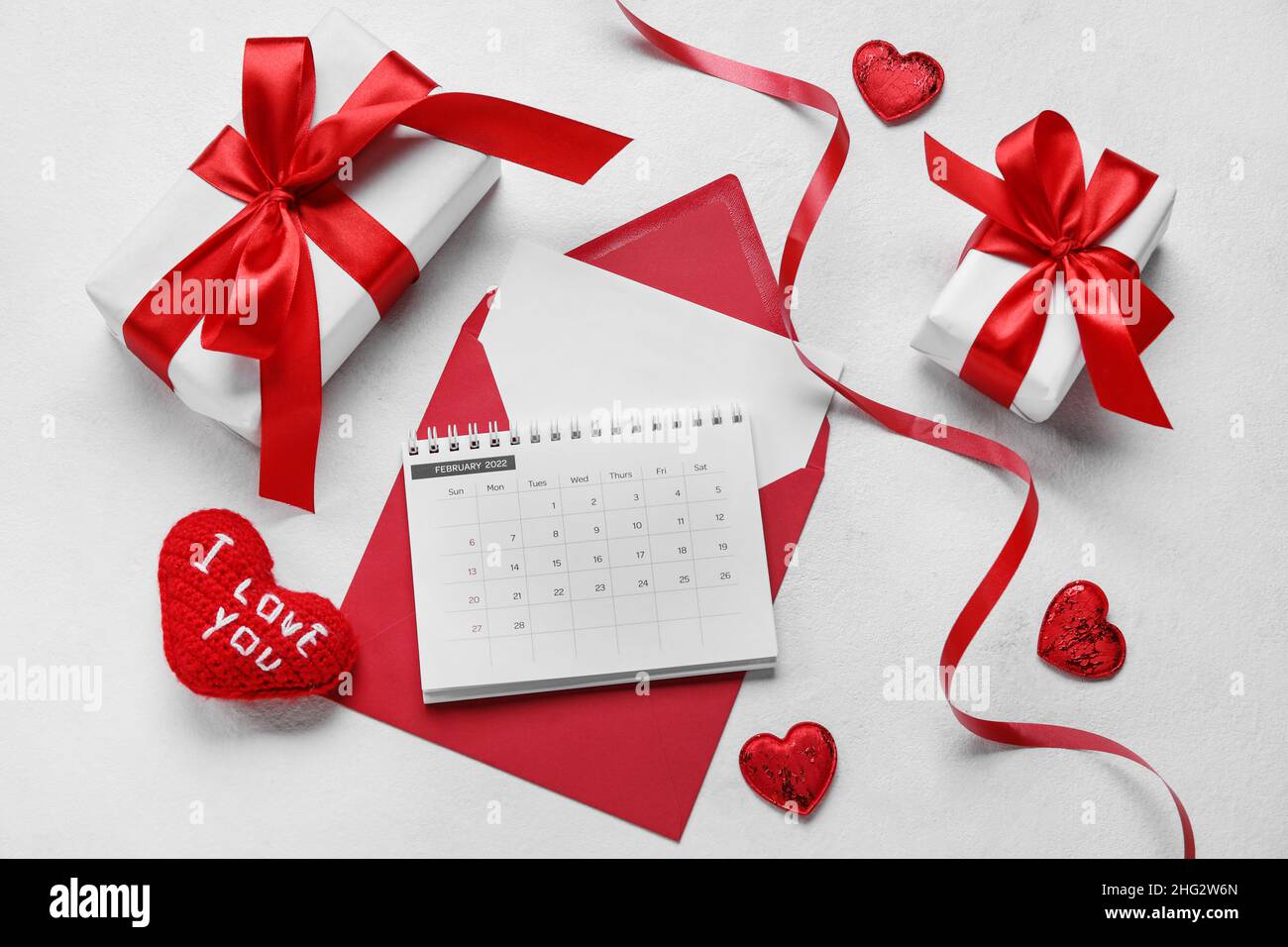 Calendar with envelope, ribbon, gifts and hearts on white background ...