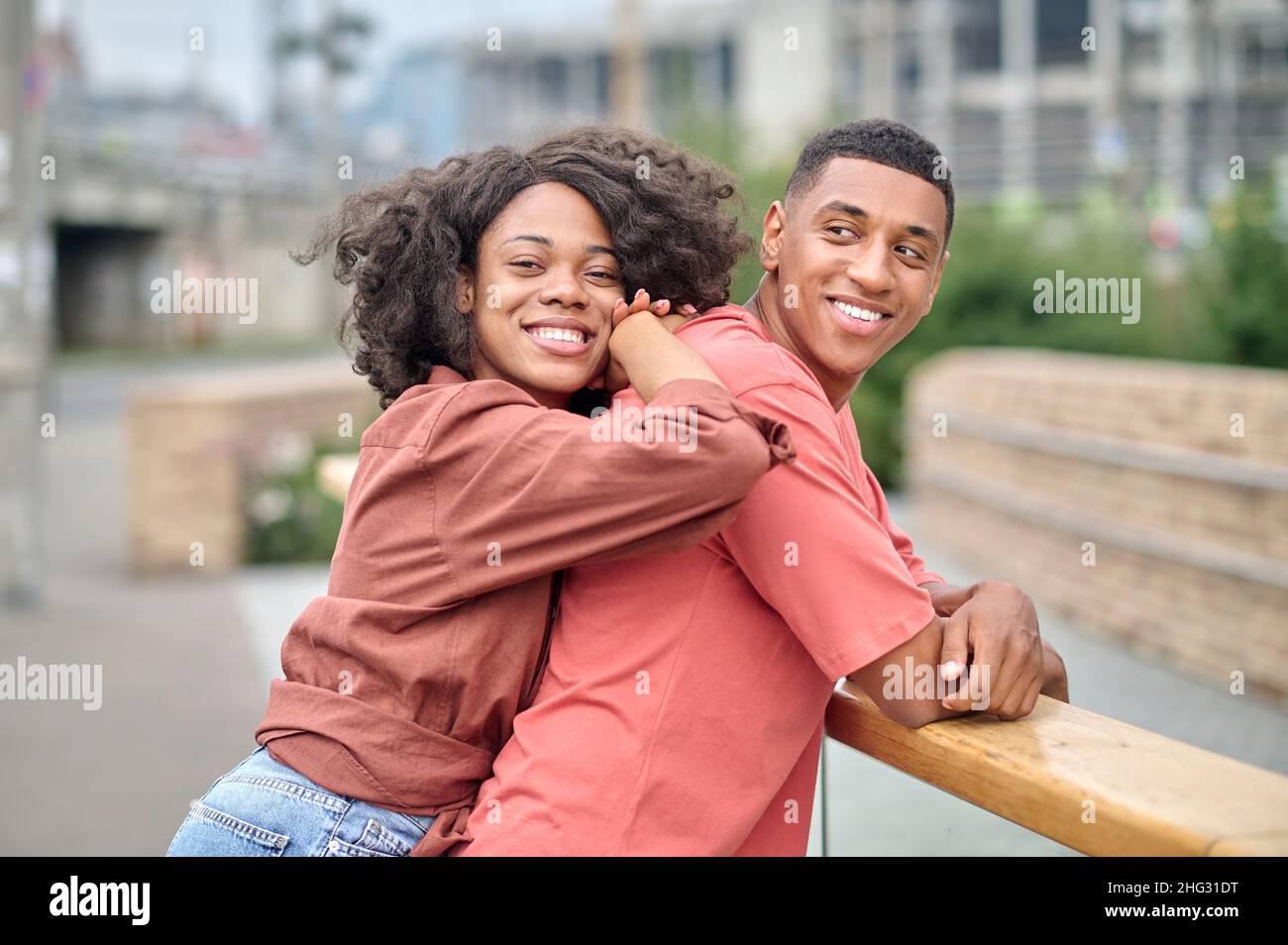 Woman leaning on back of man standing sideways to camera Stock Photo ...