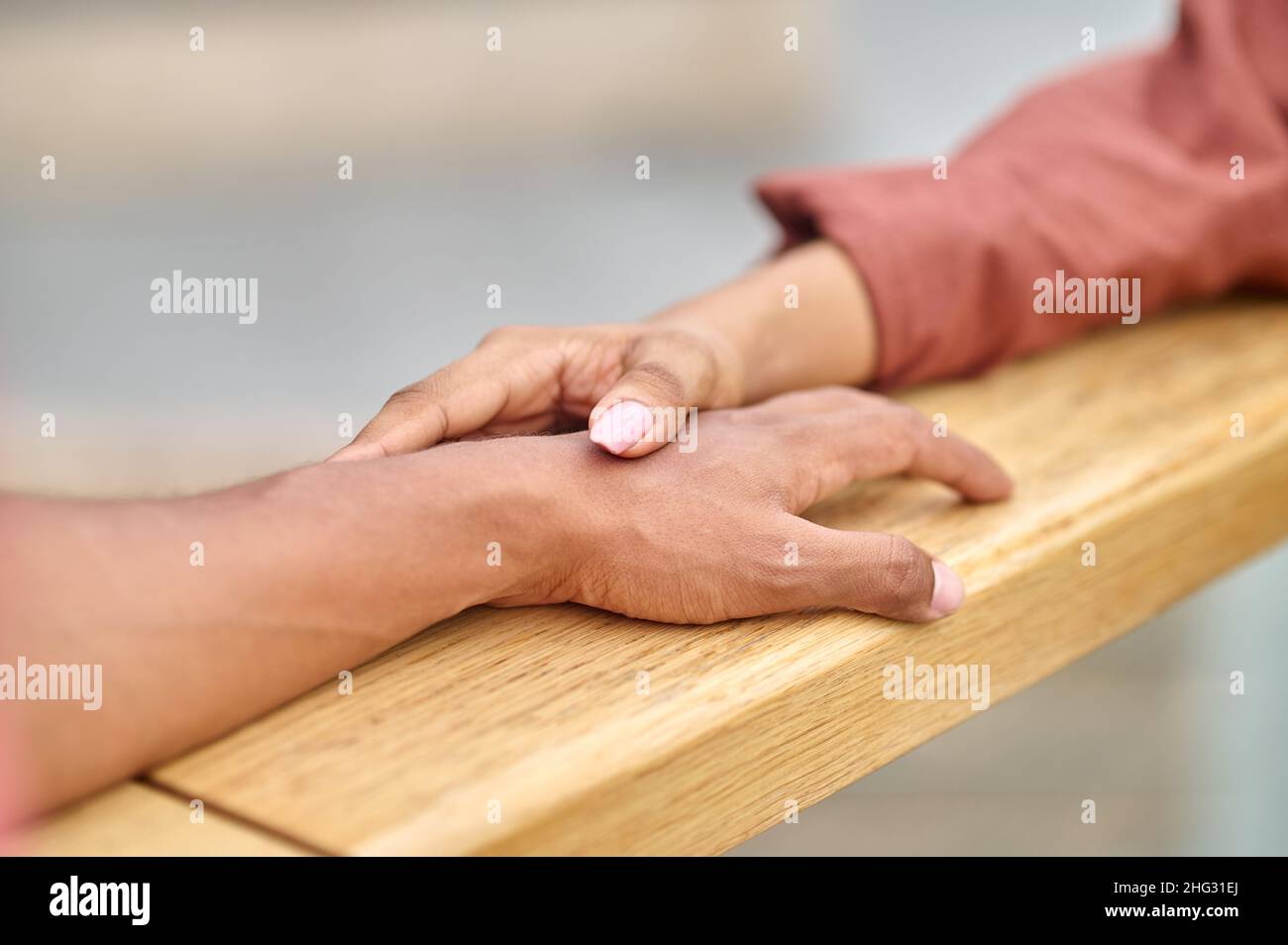 Female hand touching male hand lying on railing Stock Photo - Alamy