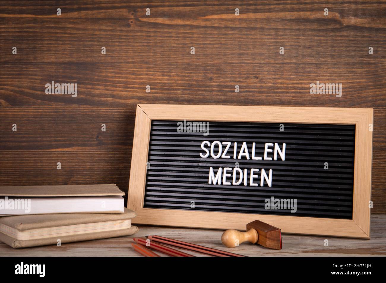 Social Media. Text in German. Colored pencils and a stack of books on ...