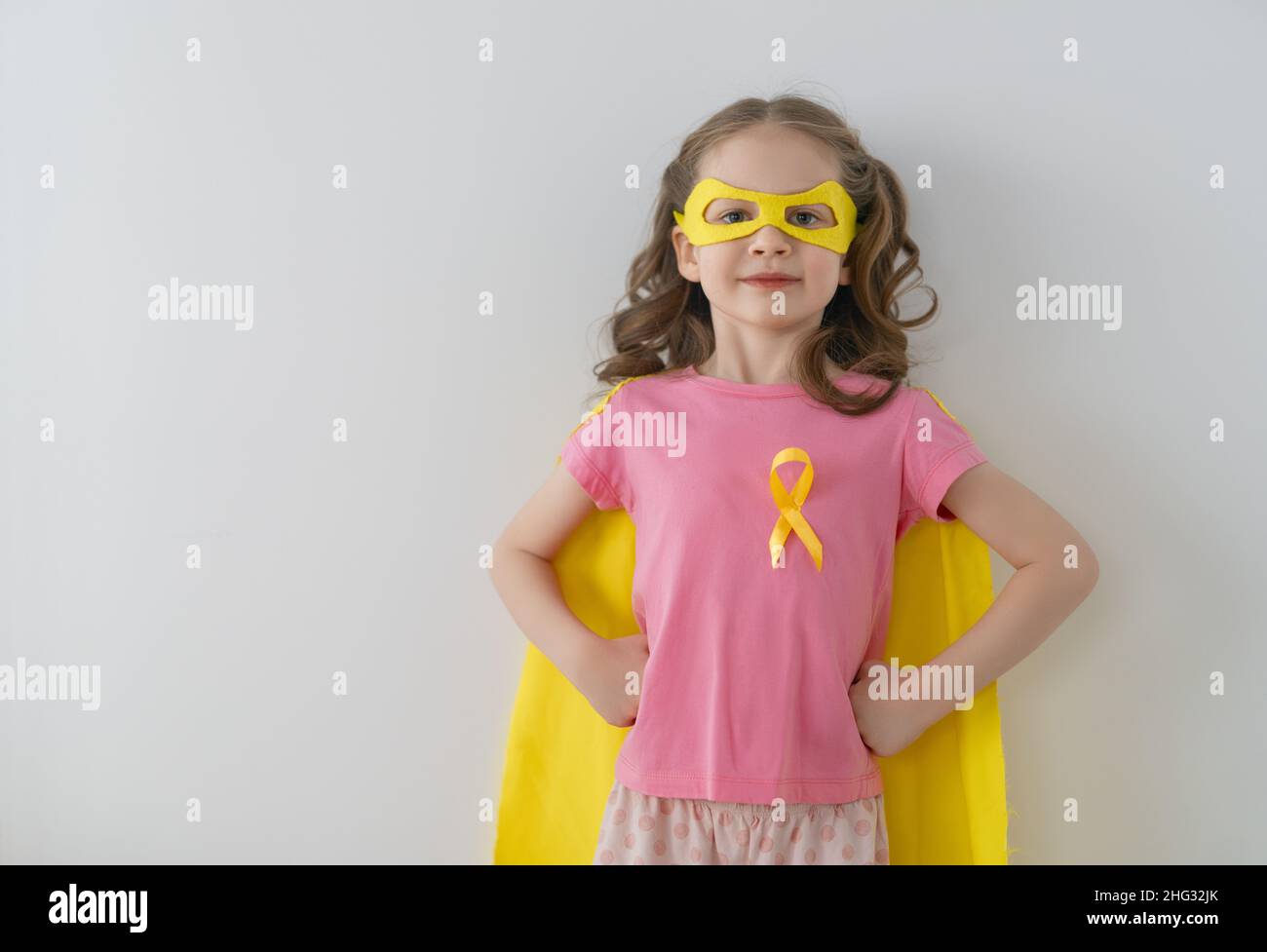 World Childhood cancer Day. Girl in superhero costume with golden ...