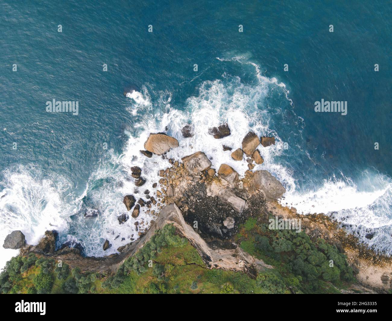 Top down aerial view of giant ocean waves crashing and foaming in coral ...