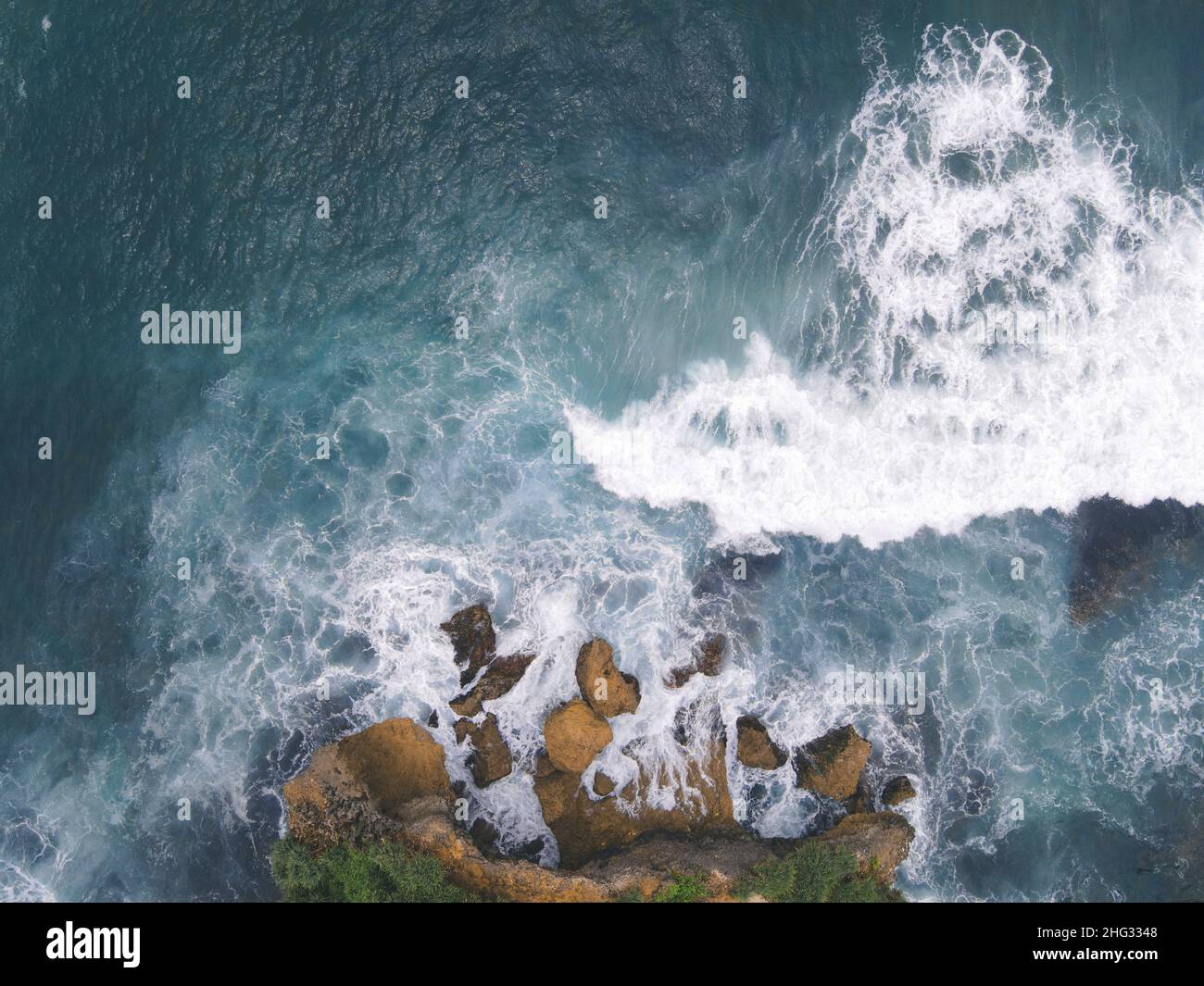 Top down aerial view of giant ocean waves crashing and foaming in coral ...
