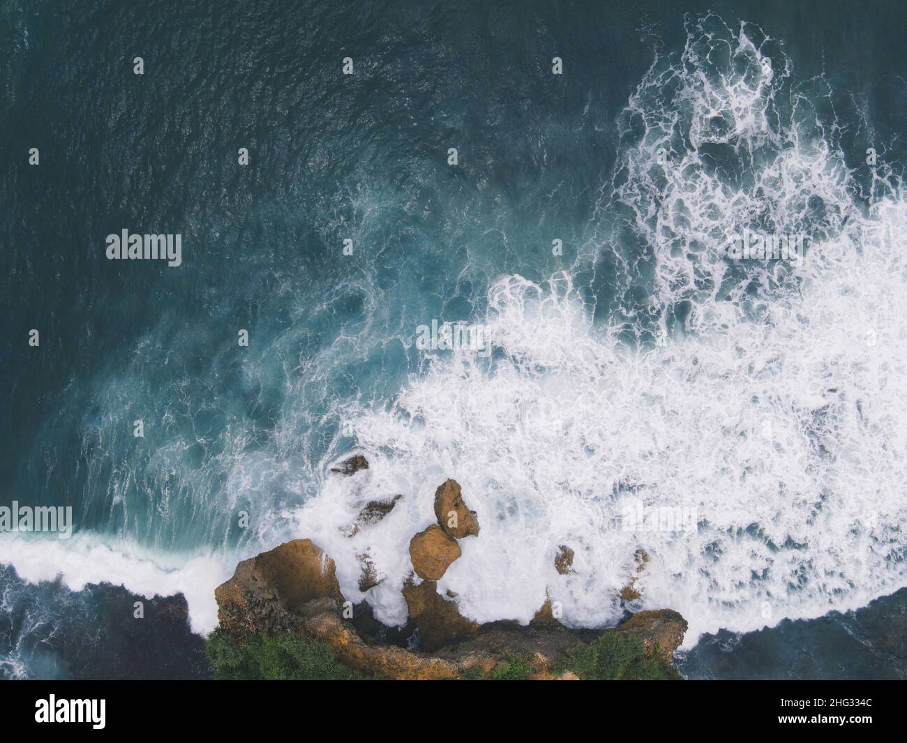 Top down aerial view of giant ocean waves crashing and foaming in coral ...