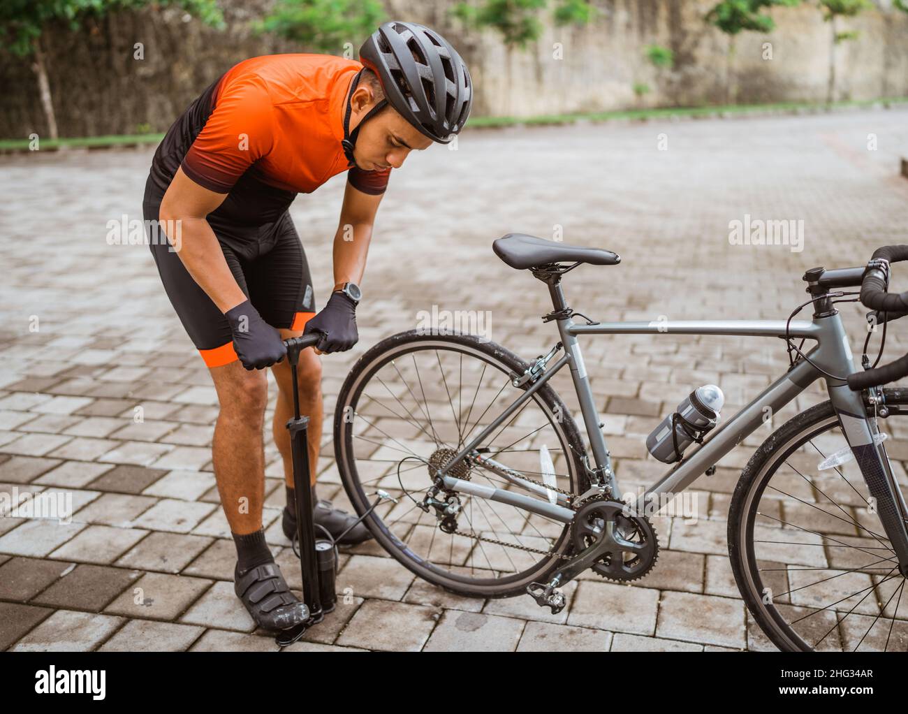 cyclist fill up the air of his bike's wheel Stock Photo - Alamy