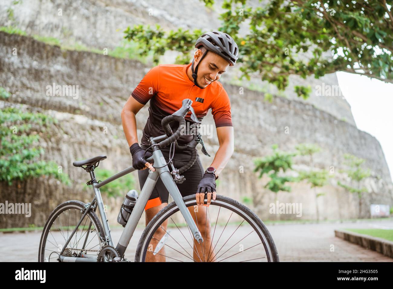 Asian male cyclist checking hi-res stock photography and images - Alamy