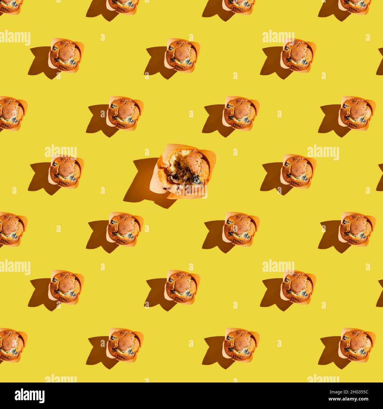 A pattern of muffins with one bitten off on a yellow background. Flat ...
