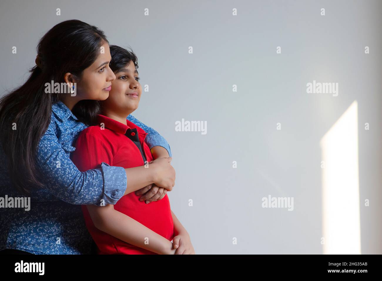 Indian woman hugging her son from backside Stock Photo - Alamy
