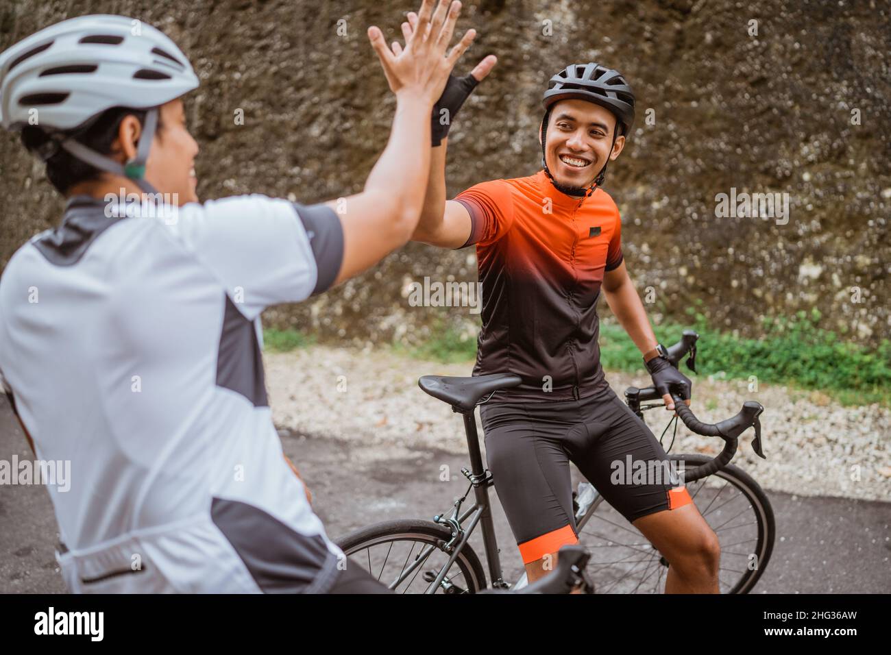 two cyclist friend high five when finish his race together Stock Photo ...