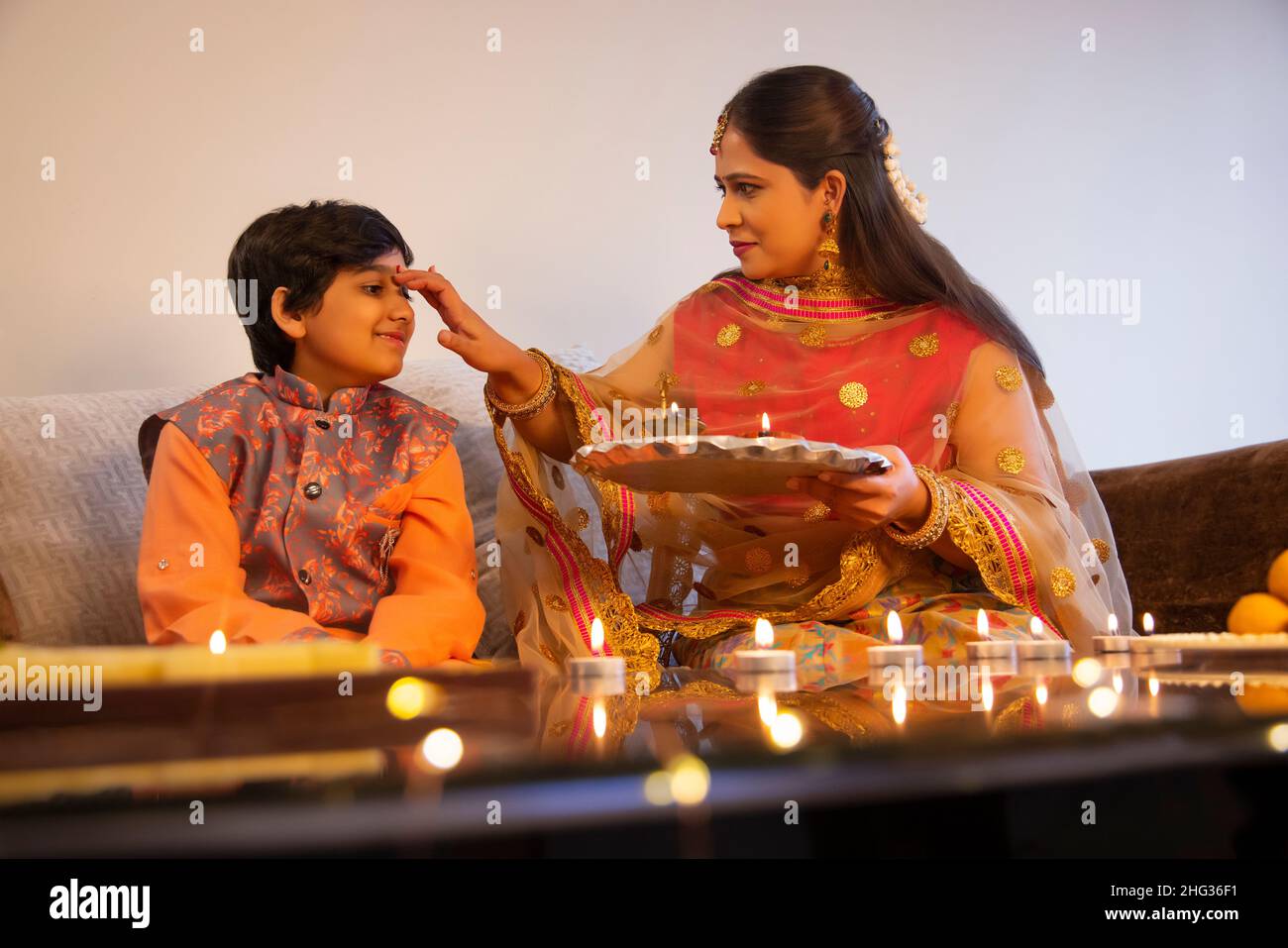 Indian woman applying tika on her son forehead on the occasion of ...