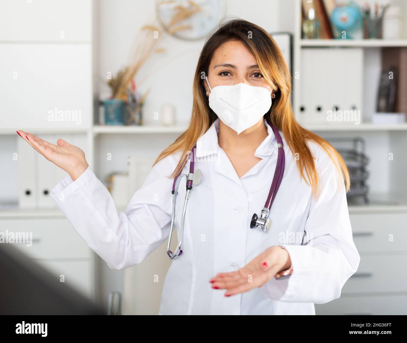 Female doctor in mask welcoming to clinic Stock Photo - Alamy