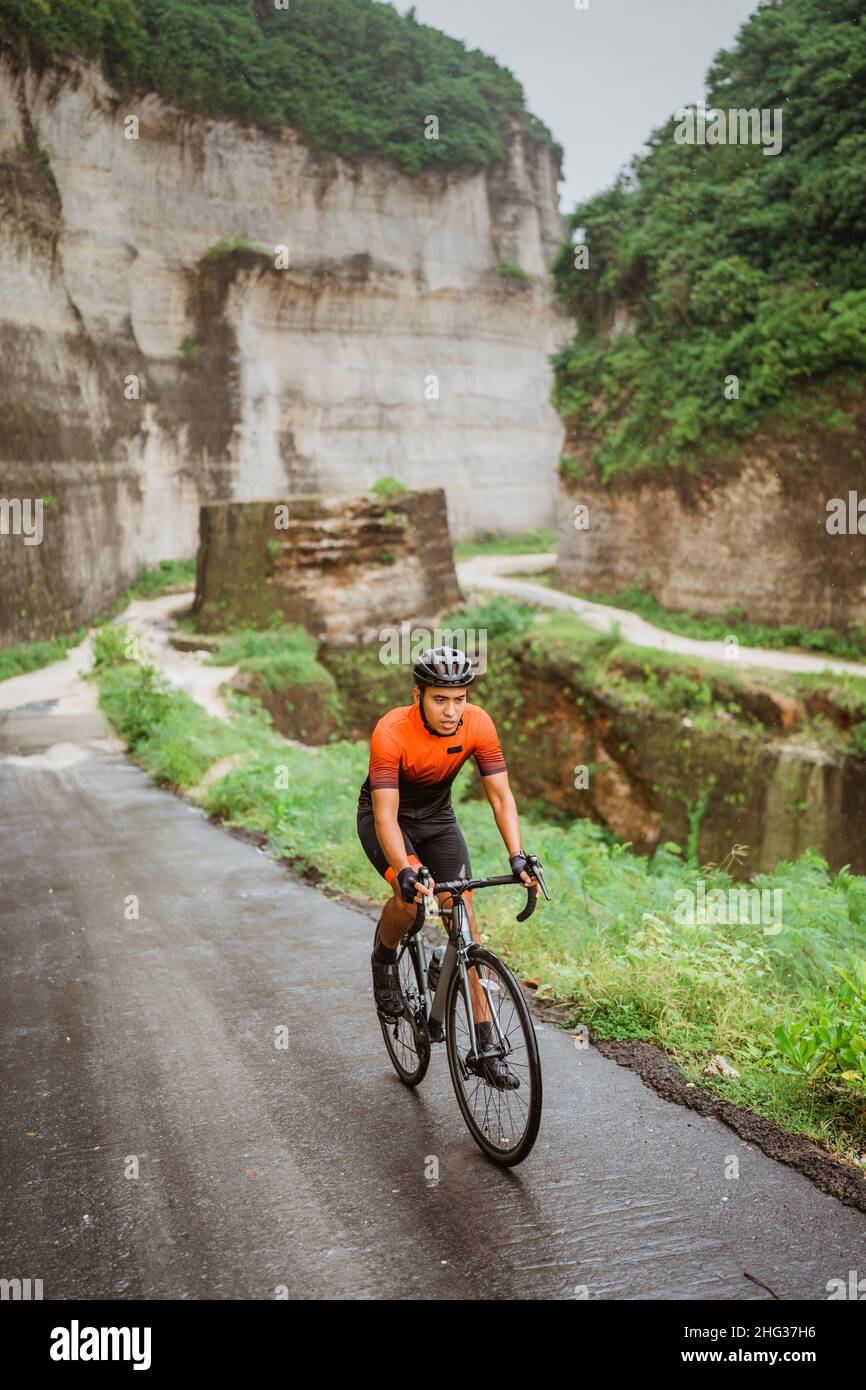 cyclist climbing up elevated road using his road bike Stock Photo - Alamy