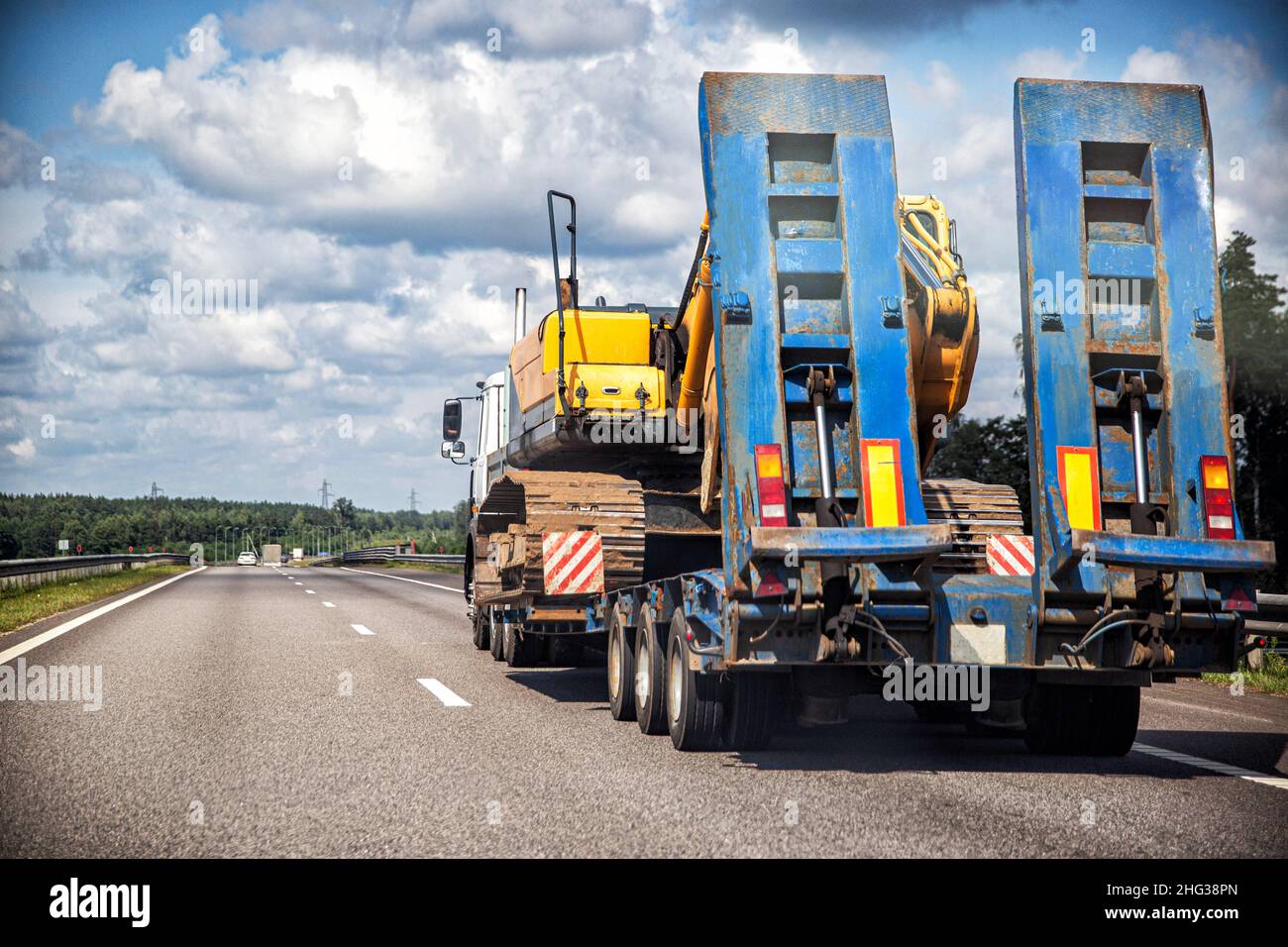 Transporting a heavy excavator in a truck trailer. Highway heavy ...