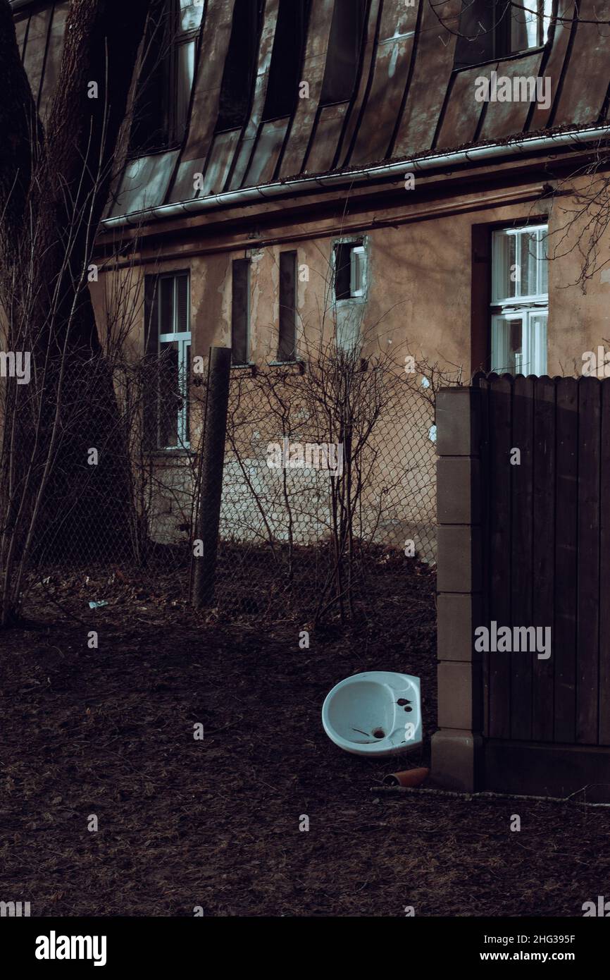 Fenced old building with a metal roof at the gate of which an old white ...