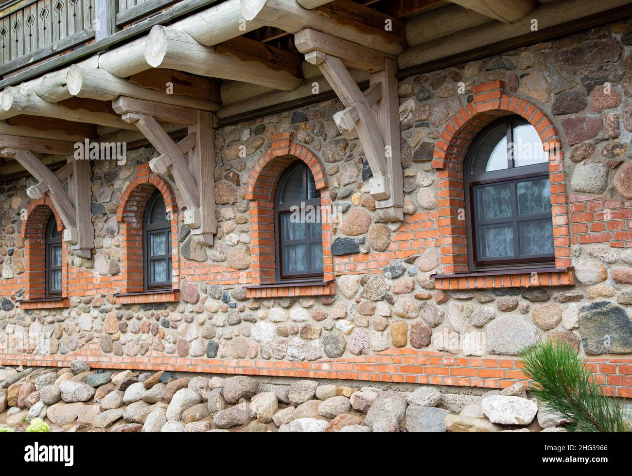 There are many semi-circular wooden windows in the stone building ...