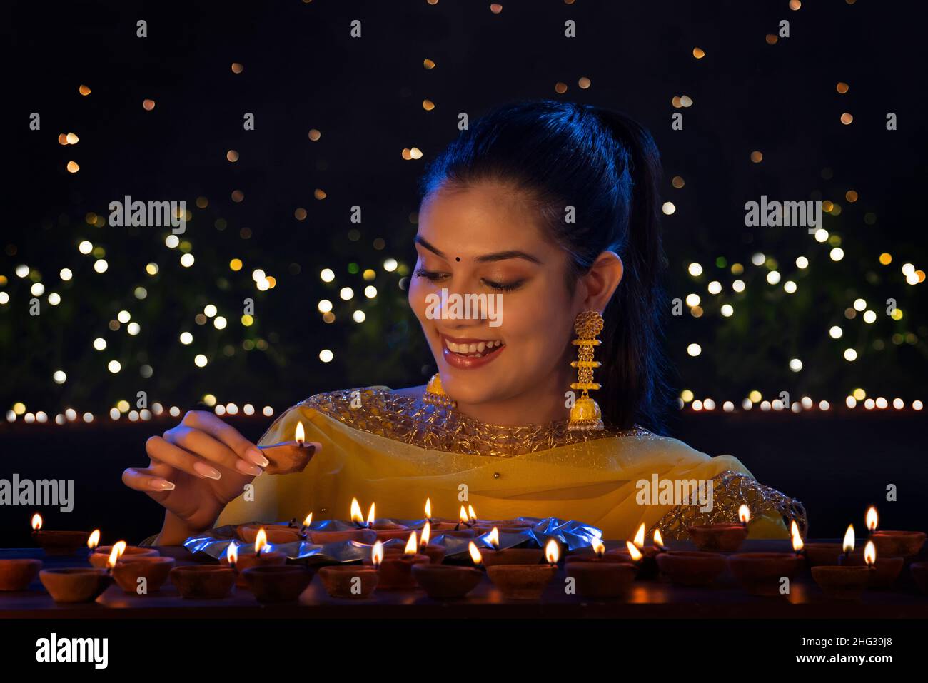Portrait of a beautiful girl placing diyas on the occasion of Diwali ...
