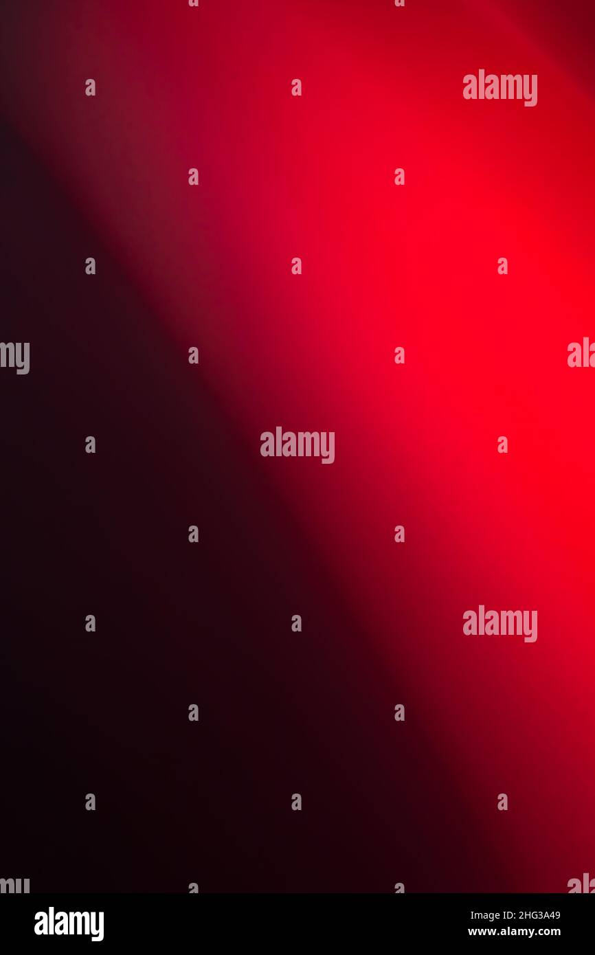 Bright red light on a black vertical background. Abstract backdrop ...