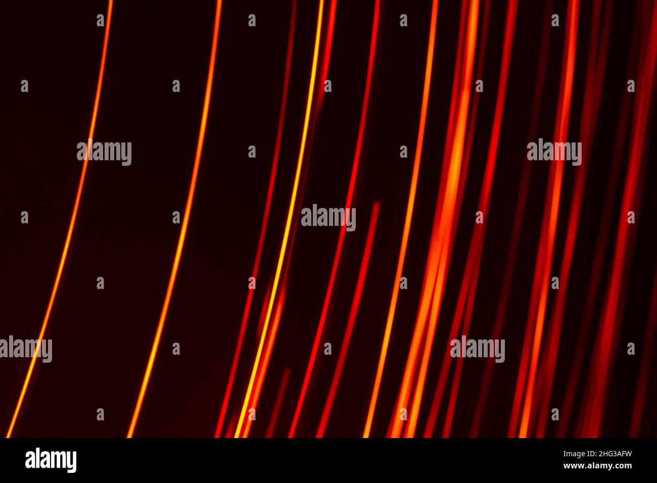 Bright red diagonal vertical lines of rays on a dark background ...