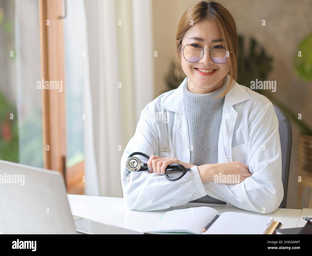 Confident and professional Asian female physician or doctor sitting ...