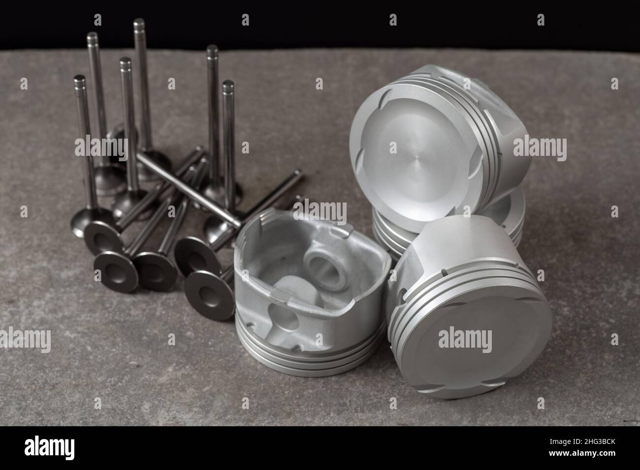 Set of new car pistons and valves on concrete gray background, car ...