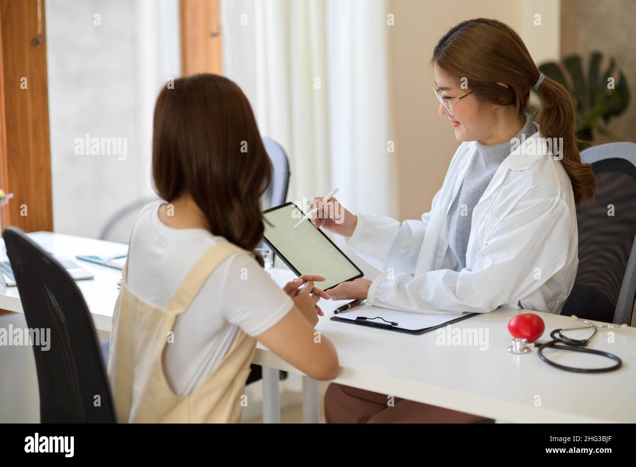 Asian young female doctor explain the medical treatment to female ...