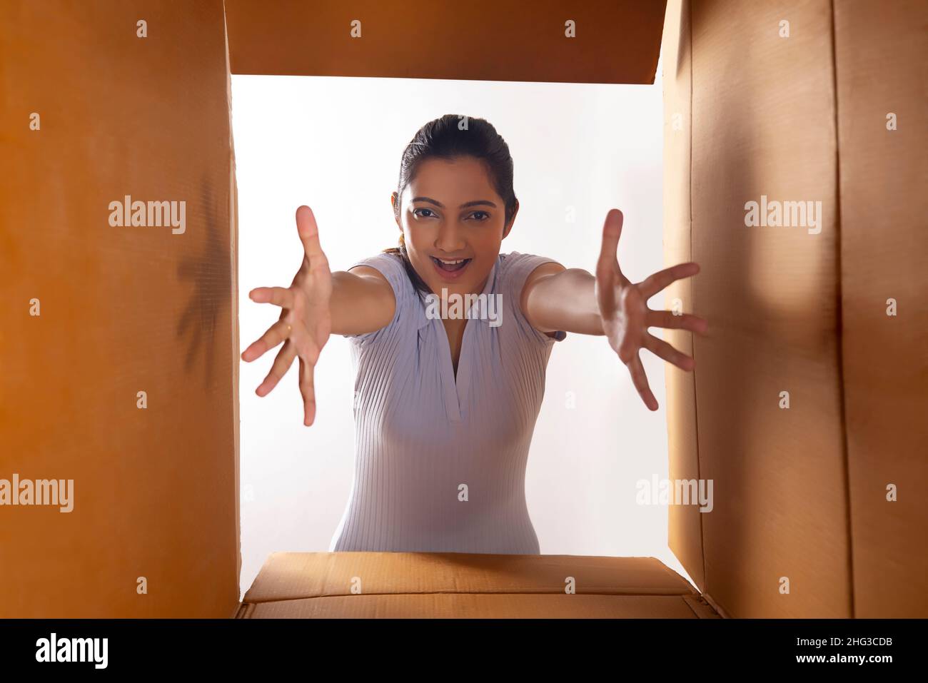 Adult girl posing in front of camera through cardboard boxes Stock ...