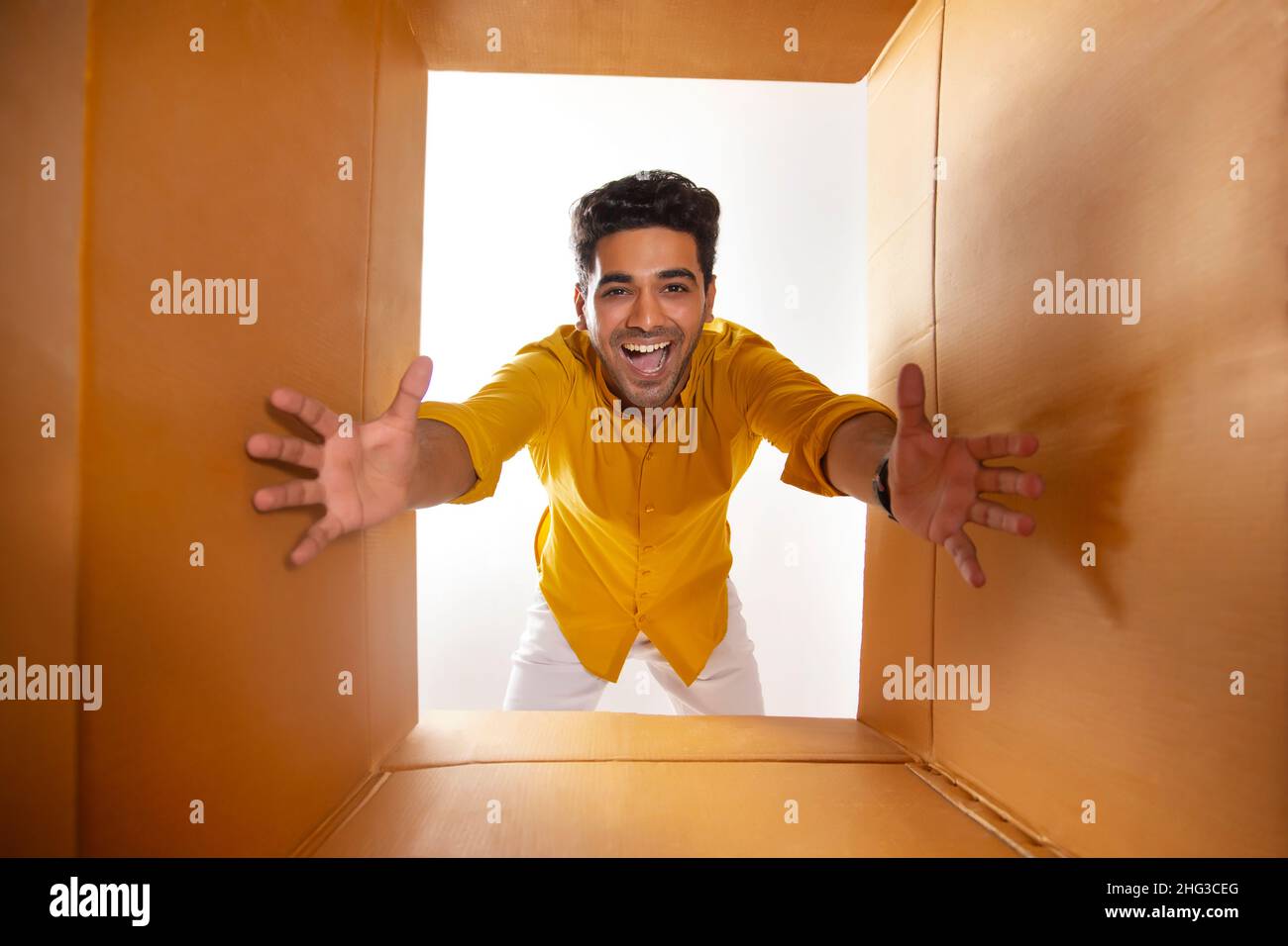 Adult boy posing in front of camera through cardboard boxes Stock Photo ...