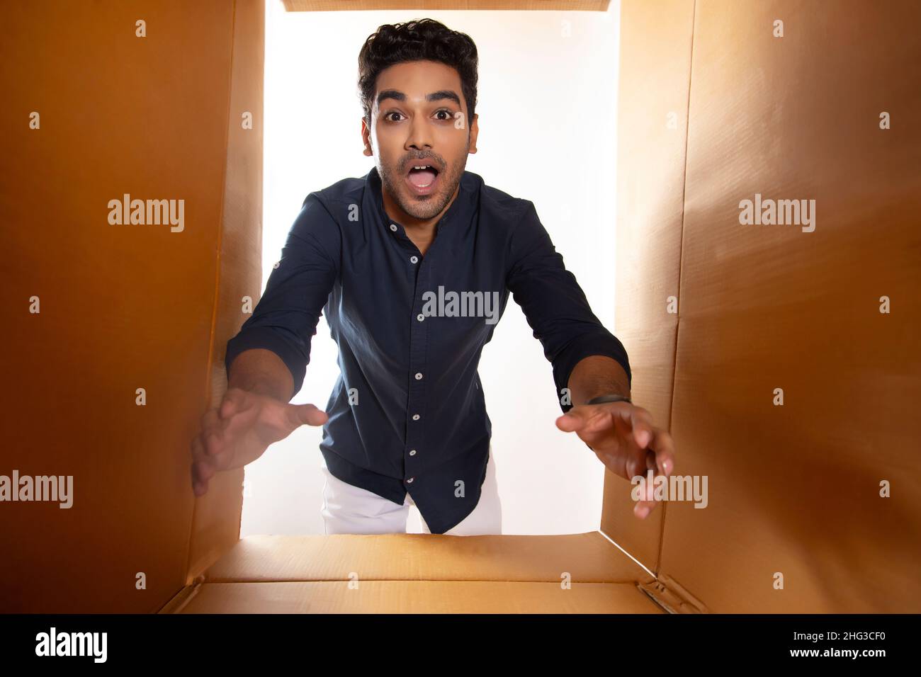 Adult boy posing in front of camera through cardboard boxes Stock Photo ...