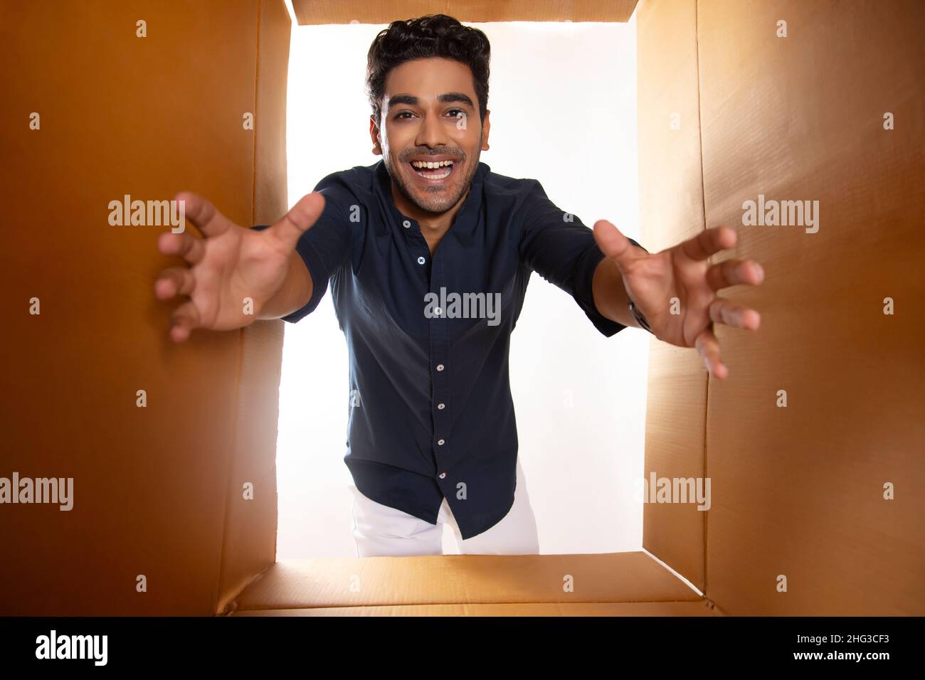 Adult boy raising his hands through cardboard boxes Stock Photo - Alamy