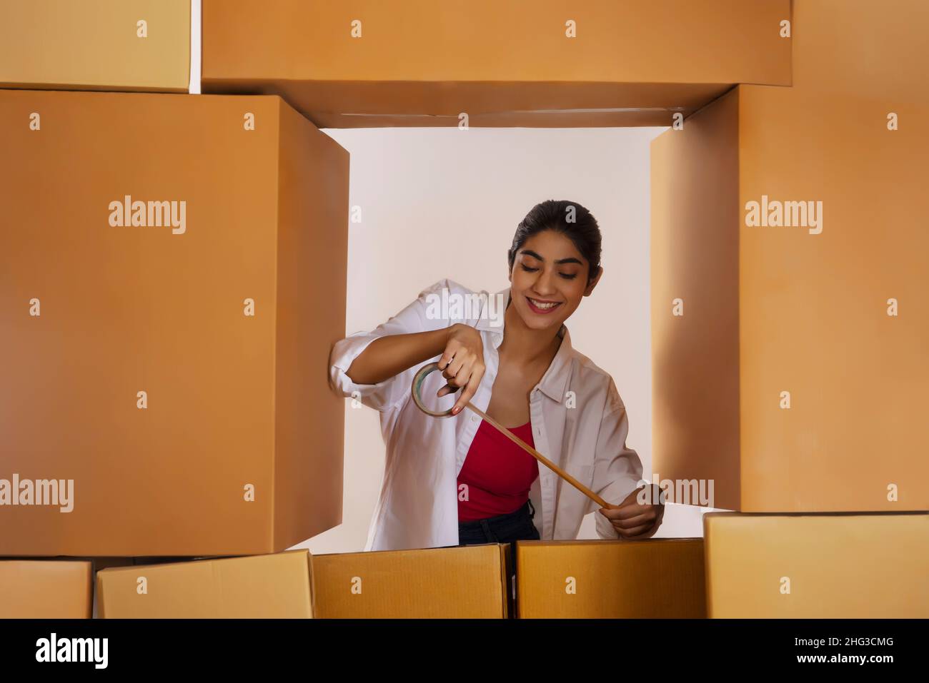 Adult girl packing cardboard box with brown tape Stock Photo - Alamy